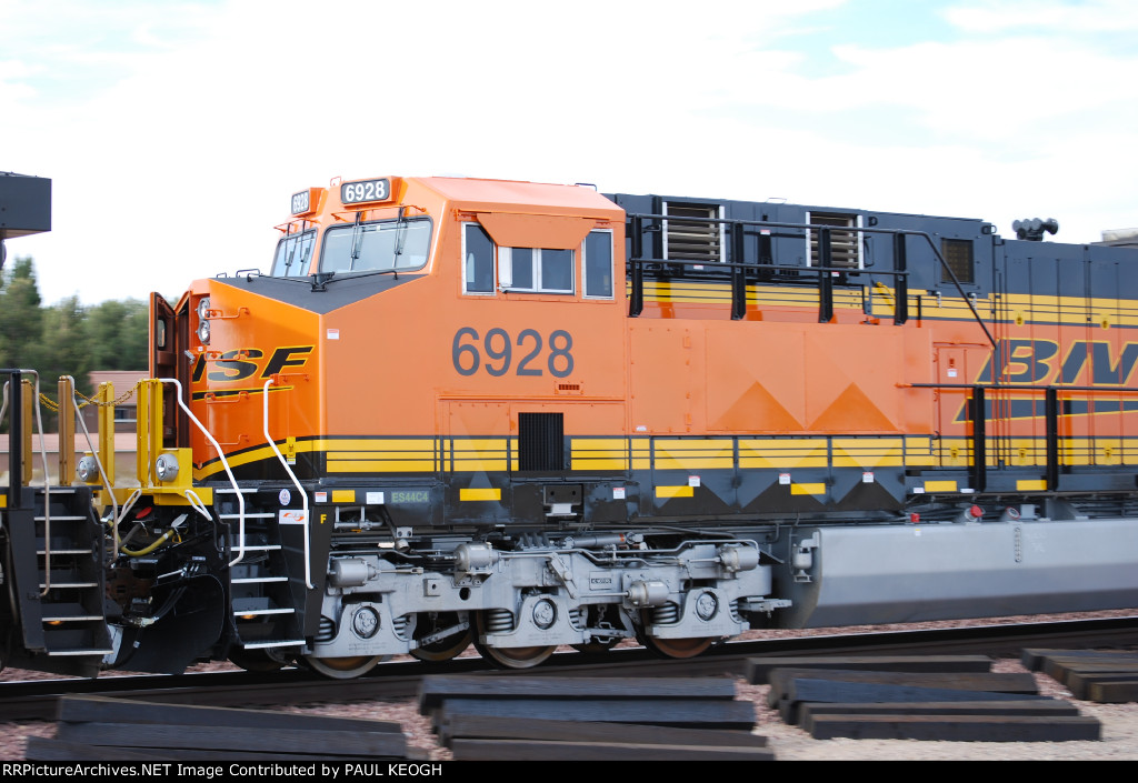 BNSF 6928 with her crew door open heads east as a rear DPU.
